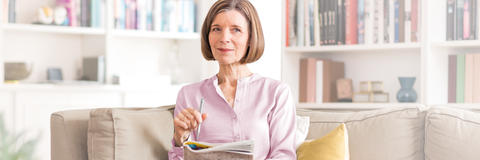 Frau trainiert ihr Gedächtnis indem sie ein Kreuzworträtsel macht